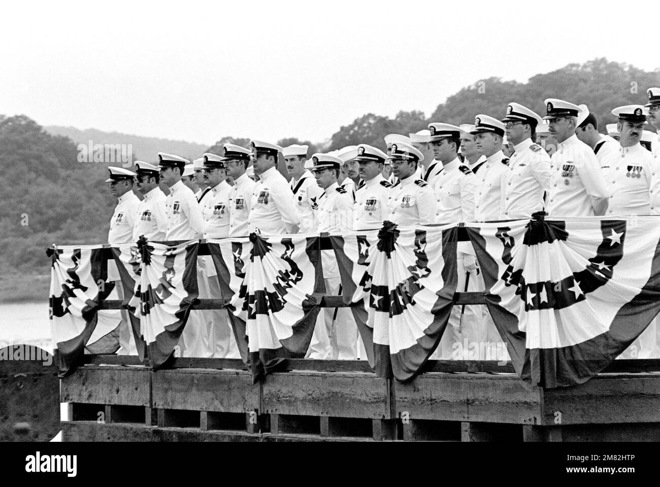 Crewmen stand in formation on a platform aboard the nuclear-powered ...