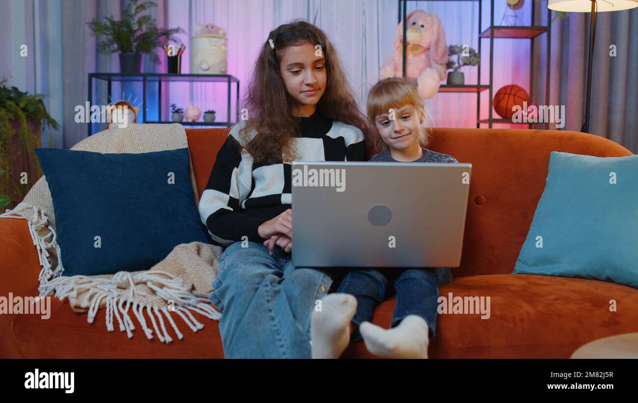 Teenage and little sisters child kids using laptop, making video webcam ...