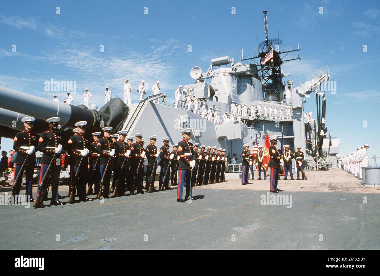 Navy crewmen man the rails and a Marine honor guard stands at parade ...