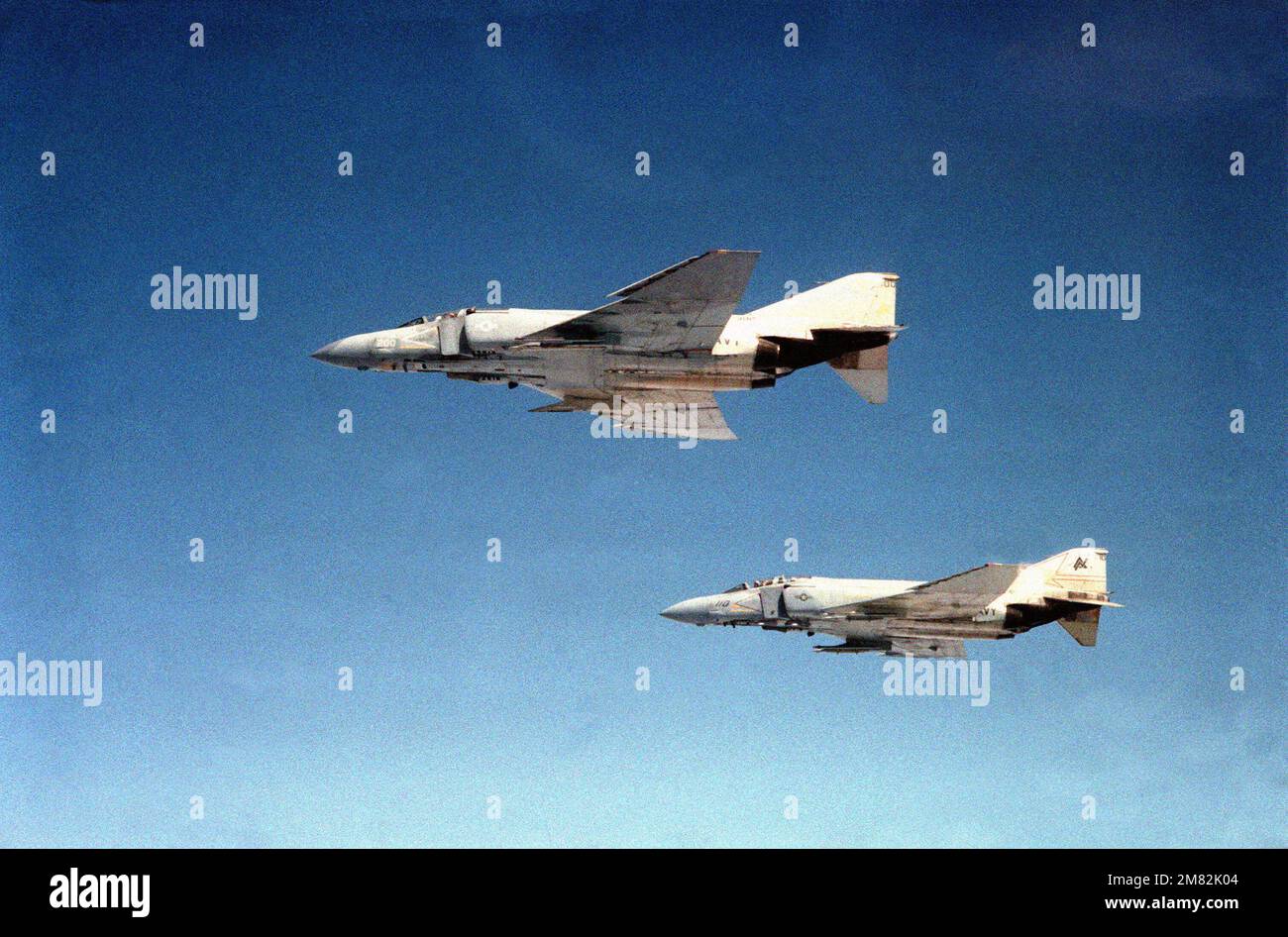 An air-to-air left side view of two F-4S Phantom II aircraft. They are ...