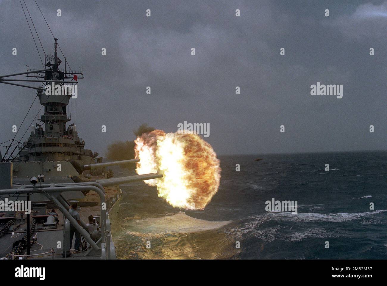 The battleship USS IOWA (BB 61) fires its 16-inch 50-cal. guns off the port side during ...