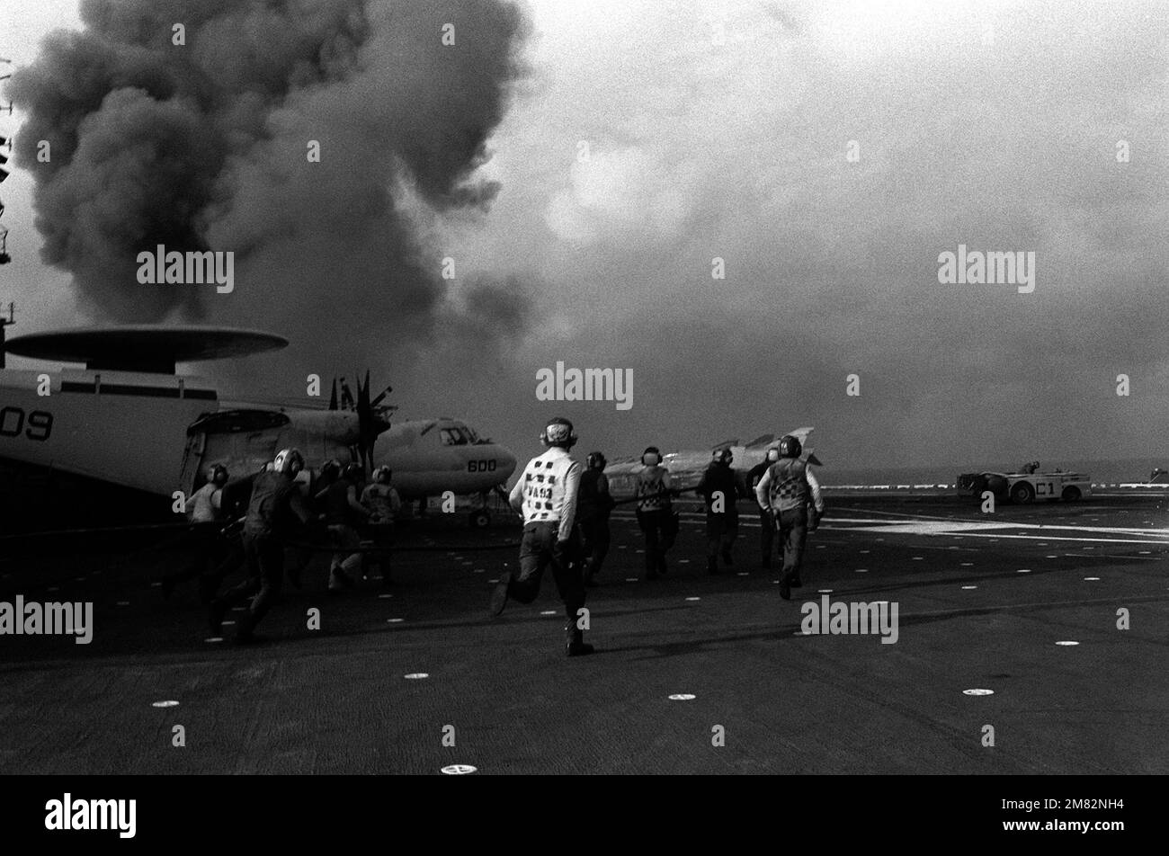 Flight deck crewmen respond to an emergency on the aircraft carrier USS ...