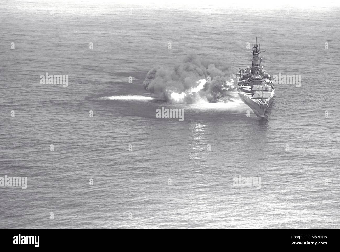 An Aerial Bow View Of The Battleship Uss Iowa Bb 61 Firing A Broadside To Starboard From The