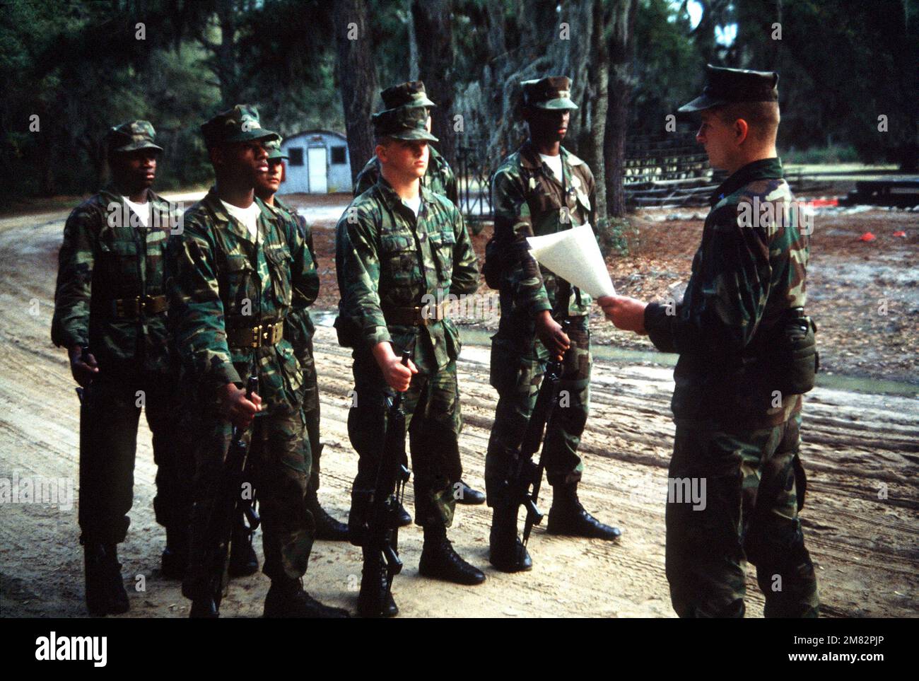 Marine recruits stand at parade rest with M16A1 rifles during basic ...