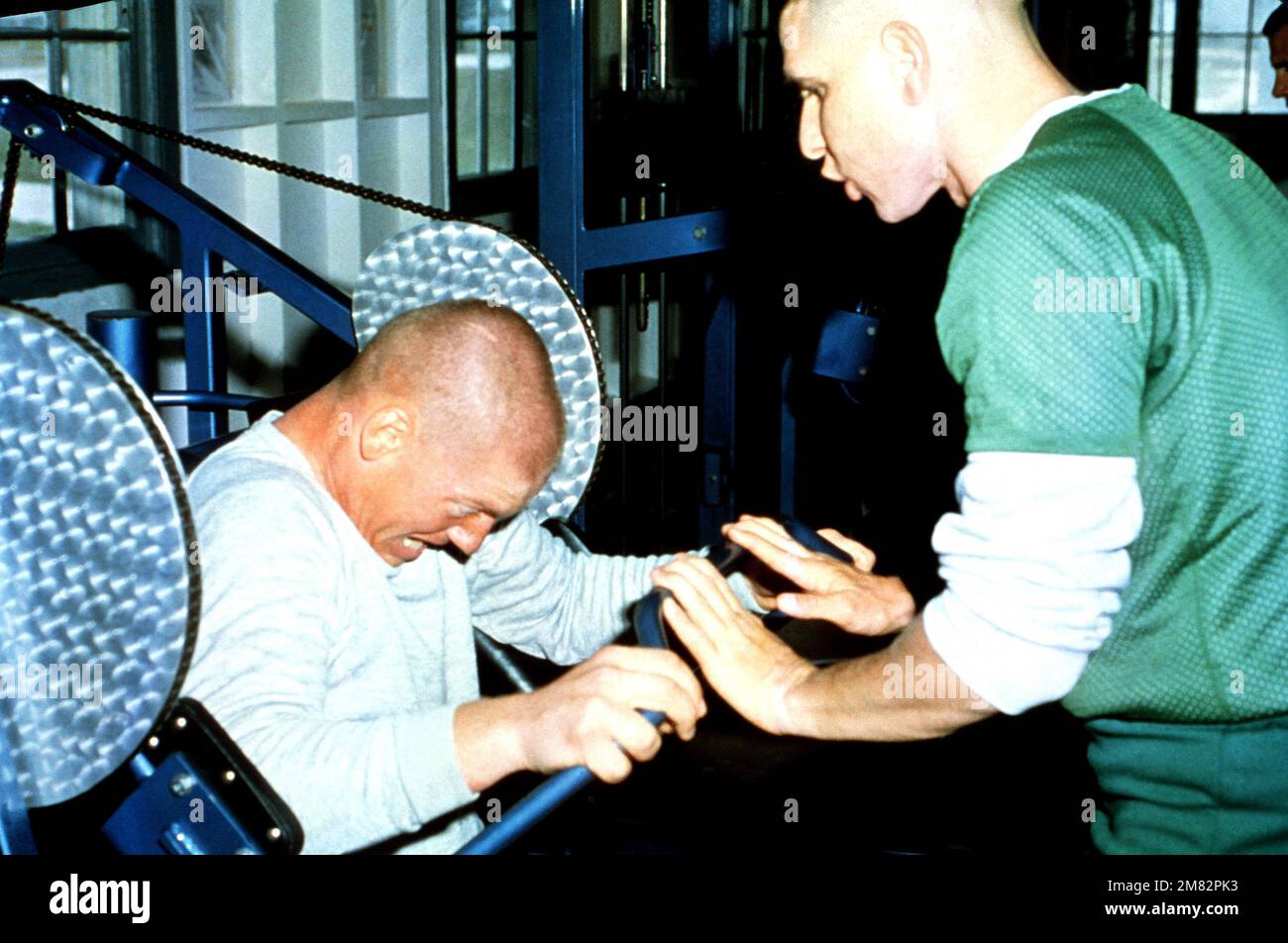 A Marine recruits performs a weight lifting exercise during basic ...