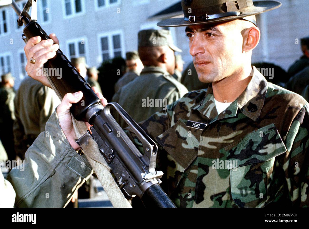 A Marine drill instructor inspects a recruit's M16A1 rifle during basic ...