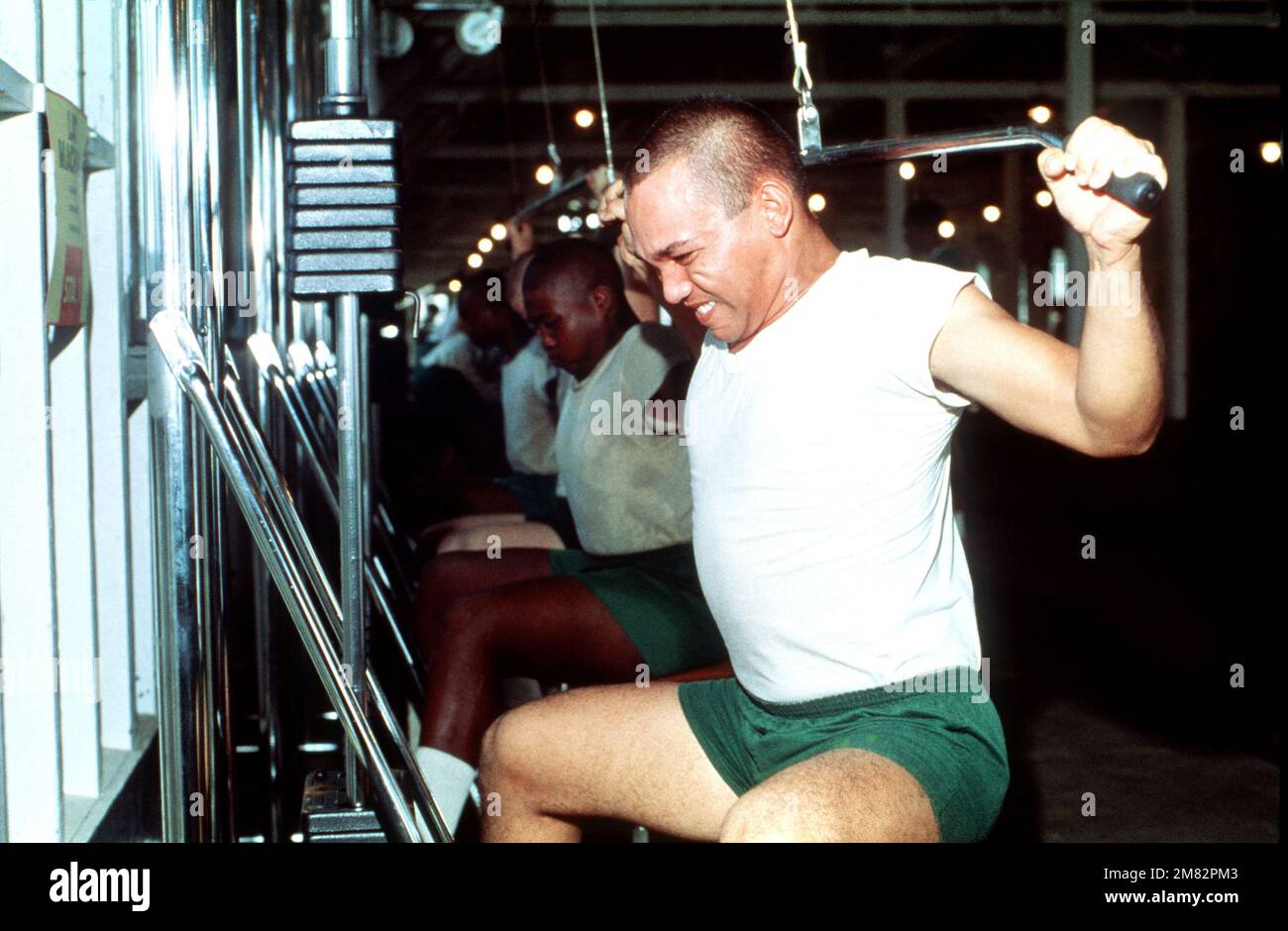 A Marine recruit performs a weight lifting exercise during basic ...