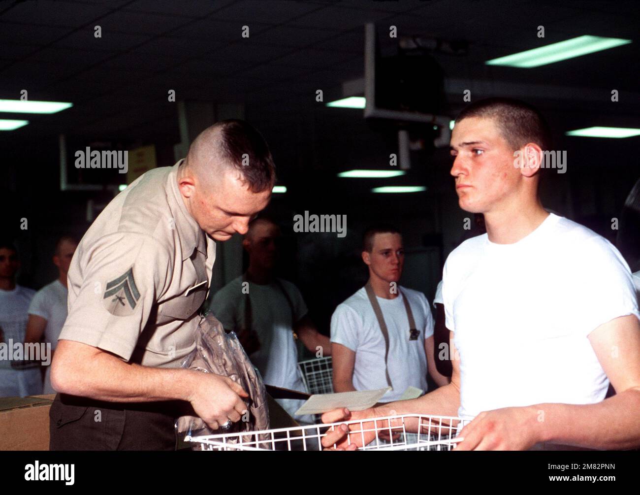 Marine recruits stand in line for uniform issue as they begin basic ...