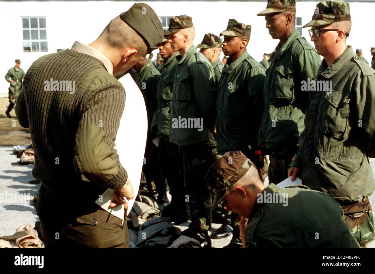 Marine recruits stand in ranks for uniform issue as they begin basic ...