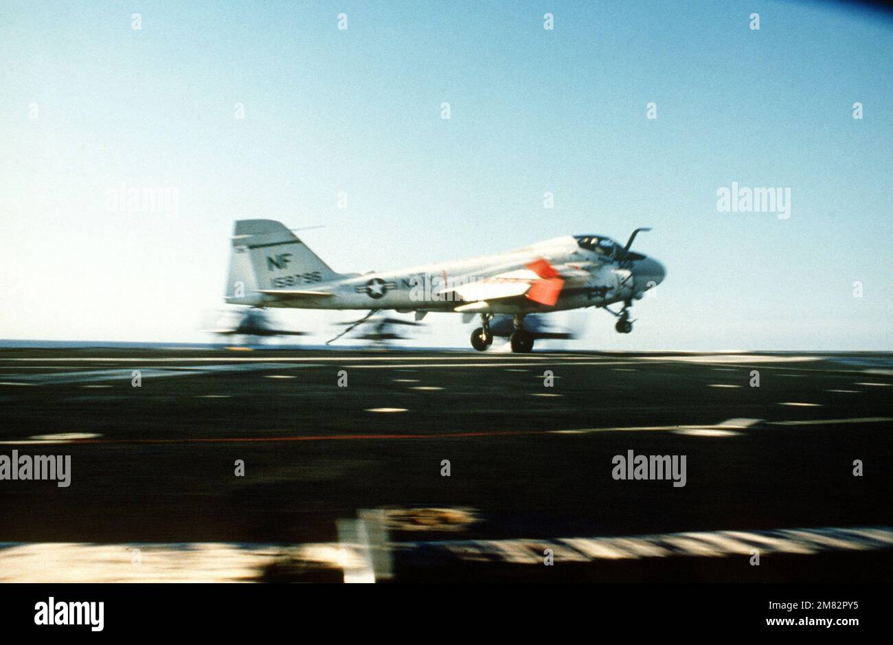 A puff of smoke comes up from the wheel of an A-6E Intruder touching ...
