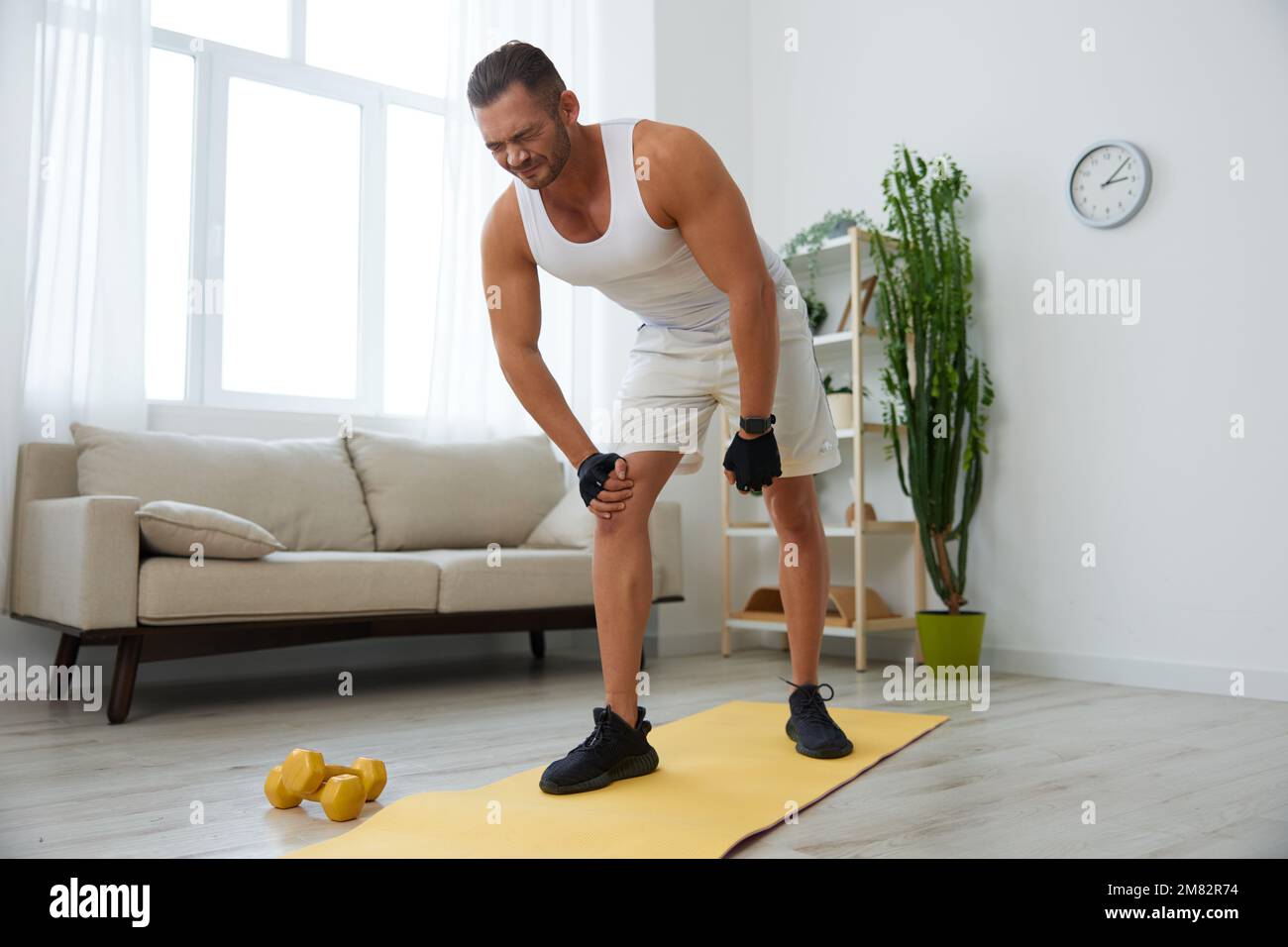 Man sports home training on the floor on a mat with dumbbells ...