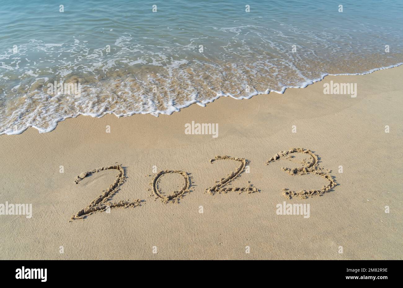 2023 handwritten in sand on a beautiful beach Stock Photo - Alamy