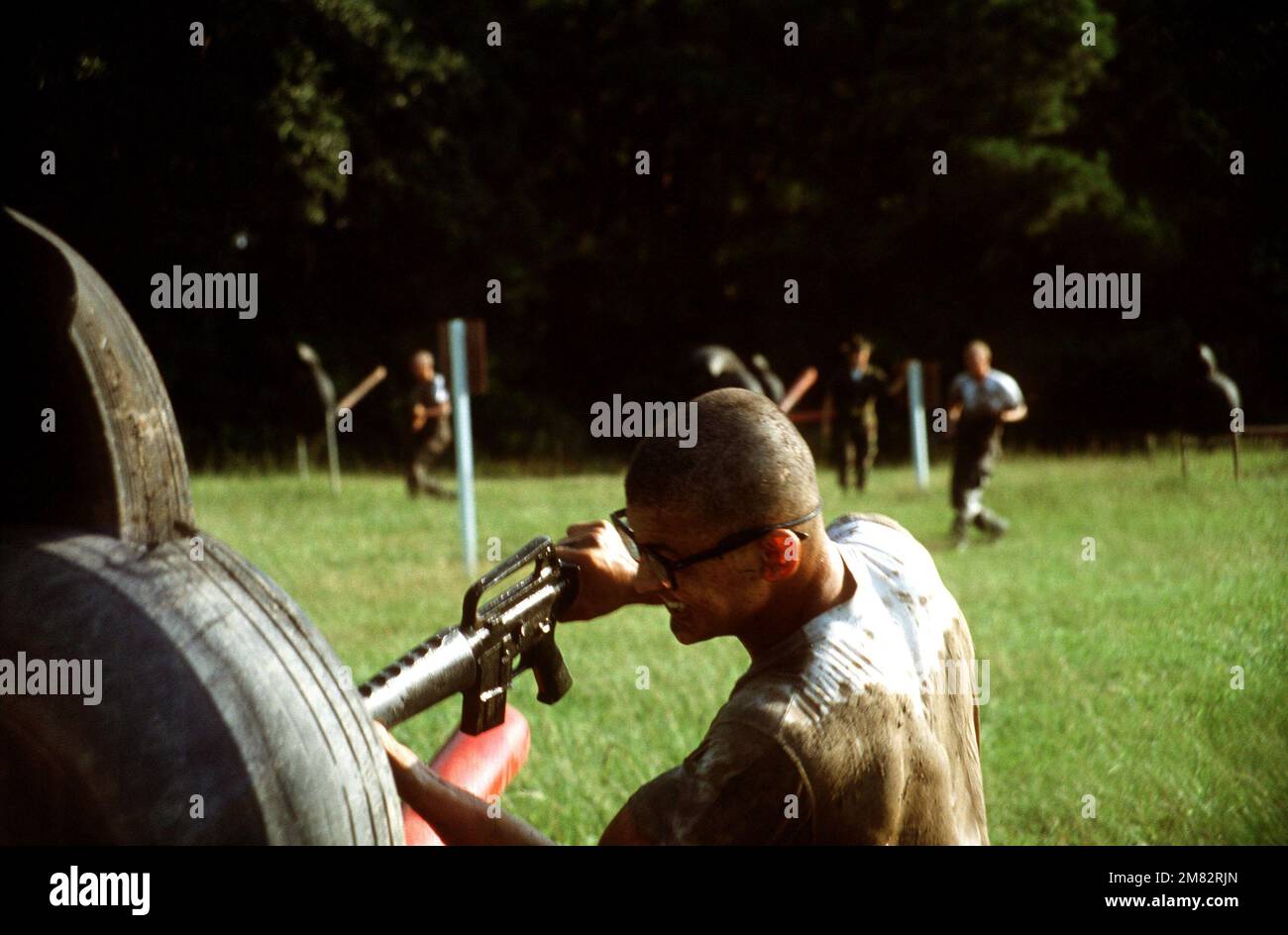 A mud-spattered recruit uses his M16A1 rifle as a hand-to-hand combat ...