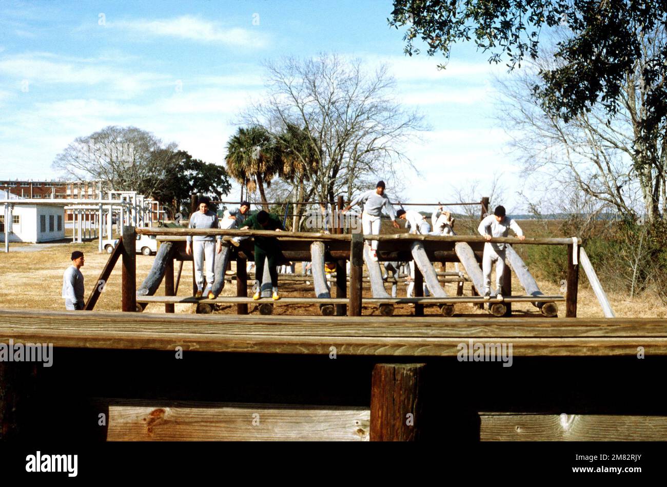 Recruits cross log bridges on the obstacle course during basic training ...