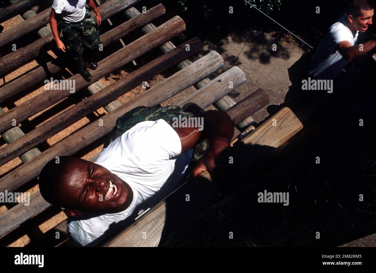 A recruit struggles to climb a tower on the obstacle course during ...