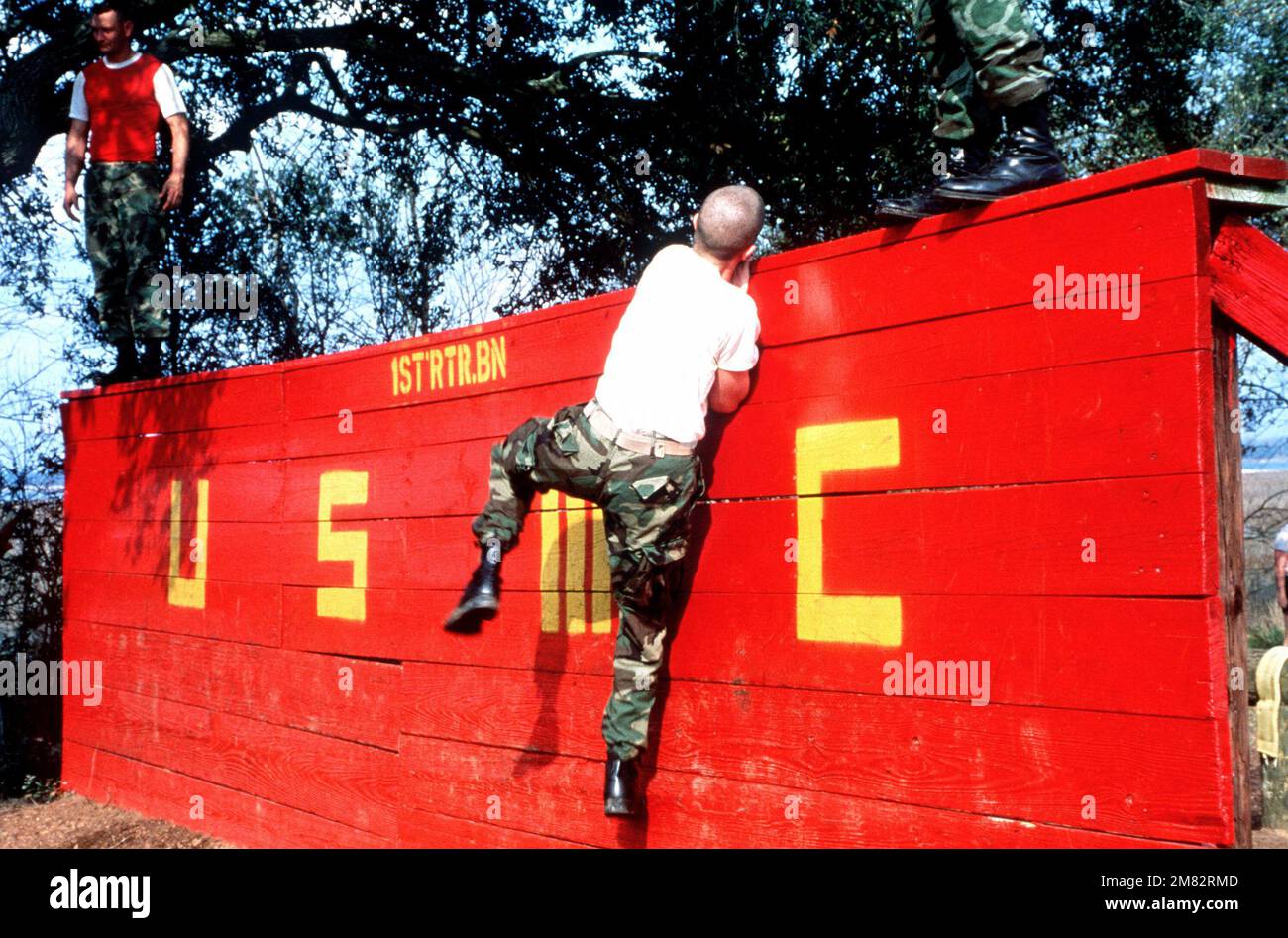 A recruit leaps onto a wall on the obstacle course during basic ...
