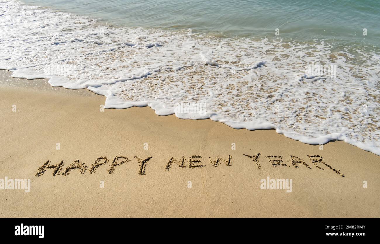 happy new year written in the sand Stock Photo - Alamy