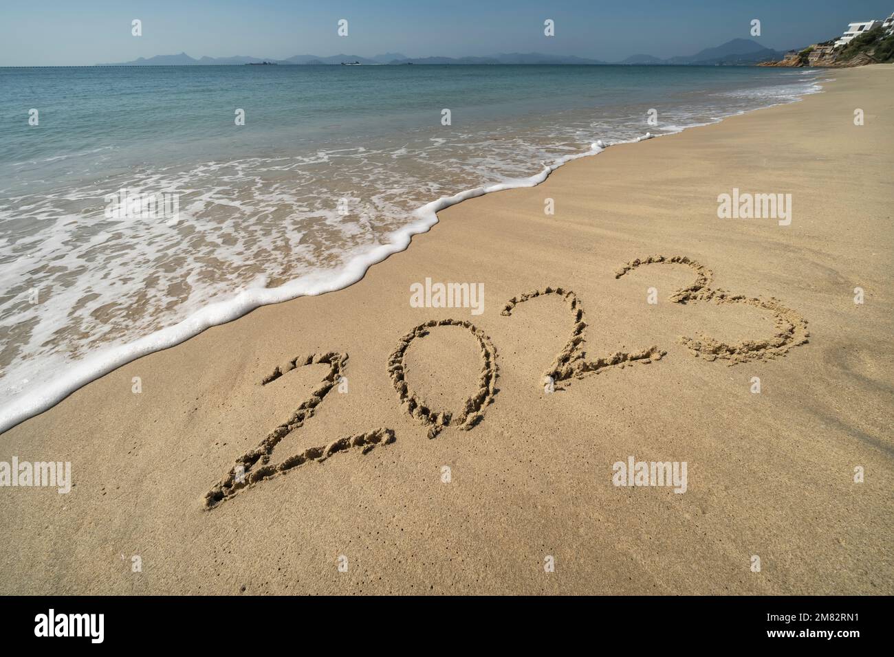 2023 handwritten in sand on a beautiful beach Stock Photo - Alamy
