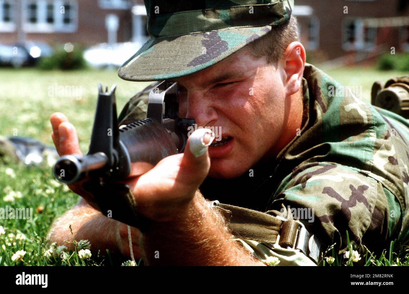 A recruit aims his M16A1 rifle from a prone position during small arms ...