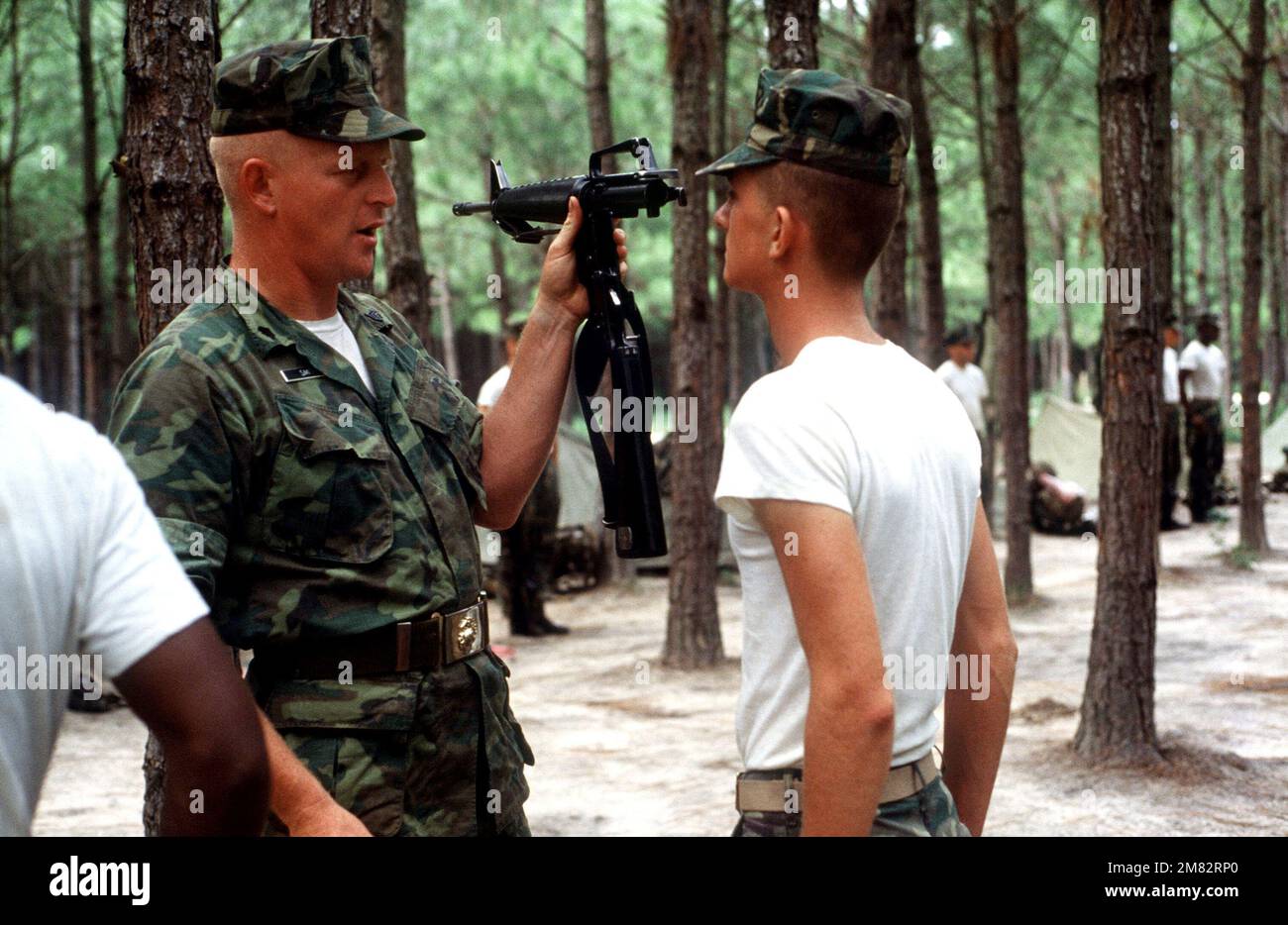 A drill instructor inspects a recruit's M16A1 rifle during individual ...