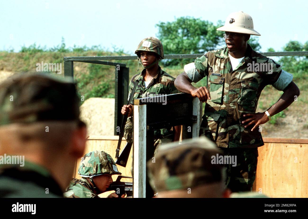 An instructor explains firing range procedures to recruits during basic ...