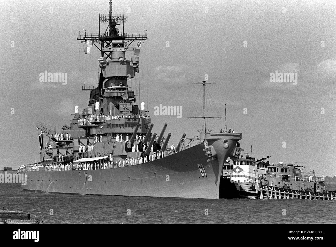 The battleship USS IOWA (BB-61) is assisted into port by the large harbor tug PALATKA (YTB-801 ...