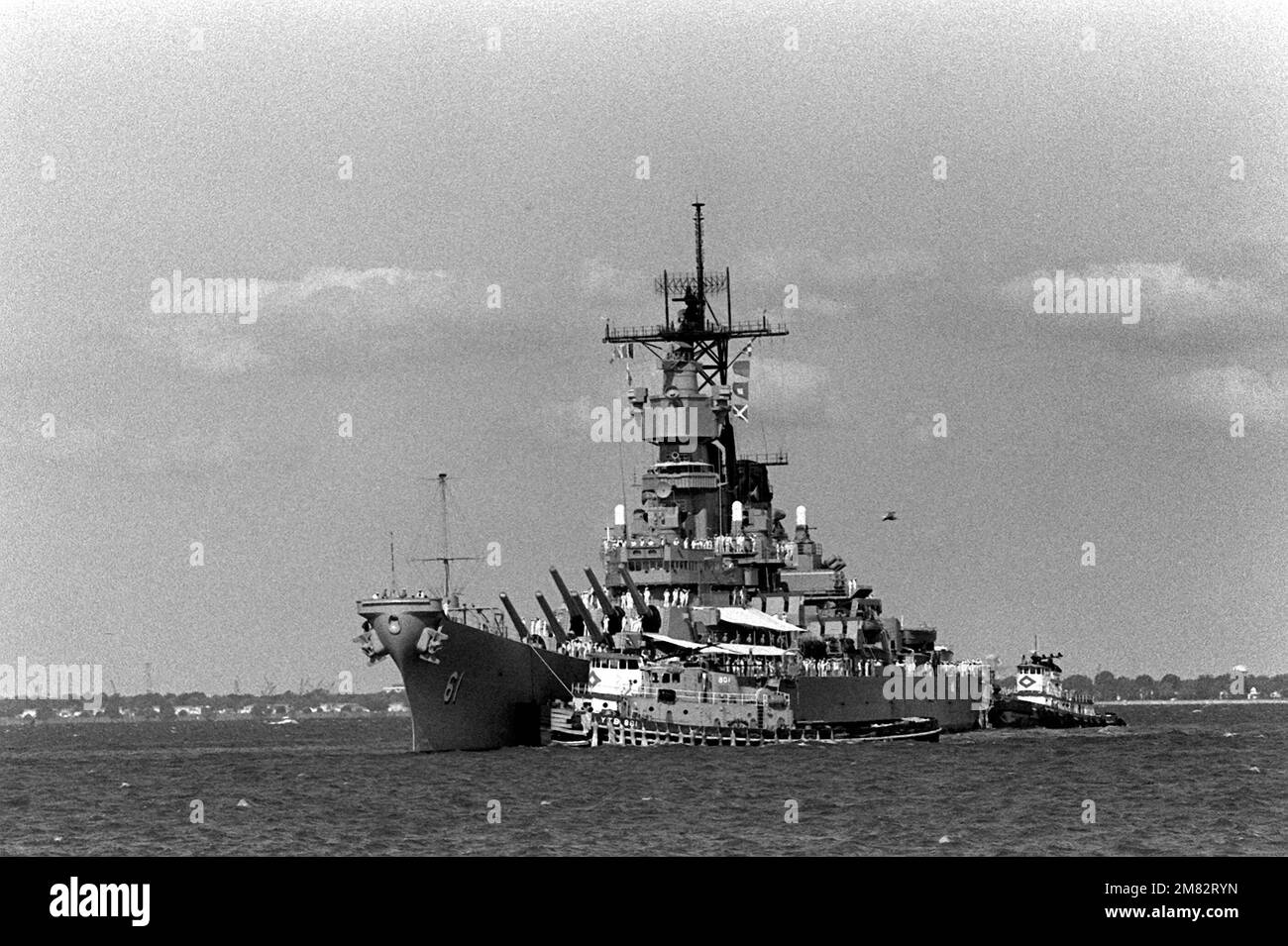 The battleship USS IOWA (BB-61) is assisted into port by the large harbor tug PALATKA (YTB-801 ...