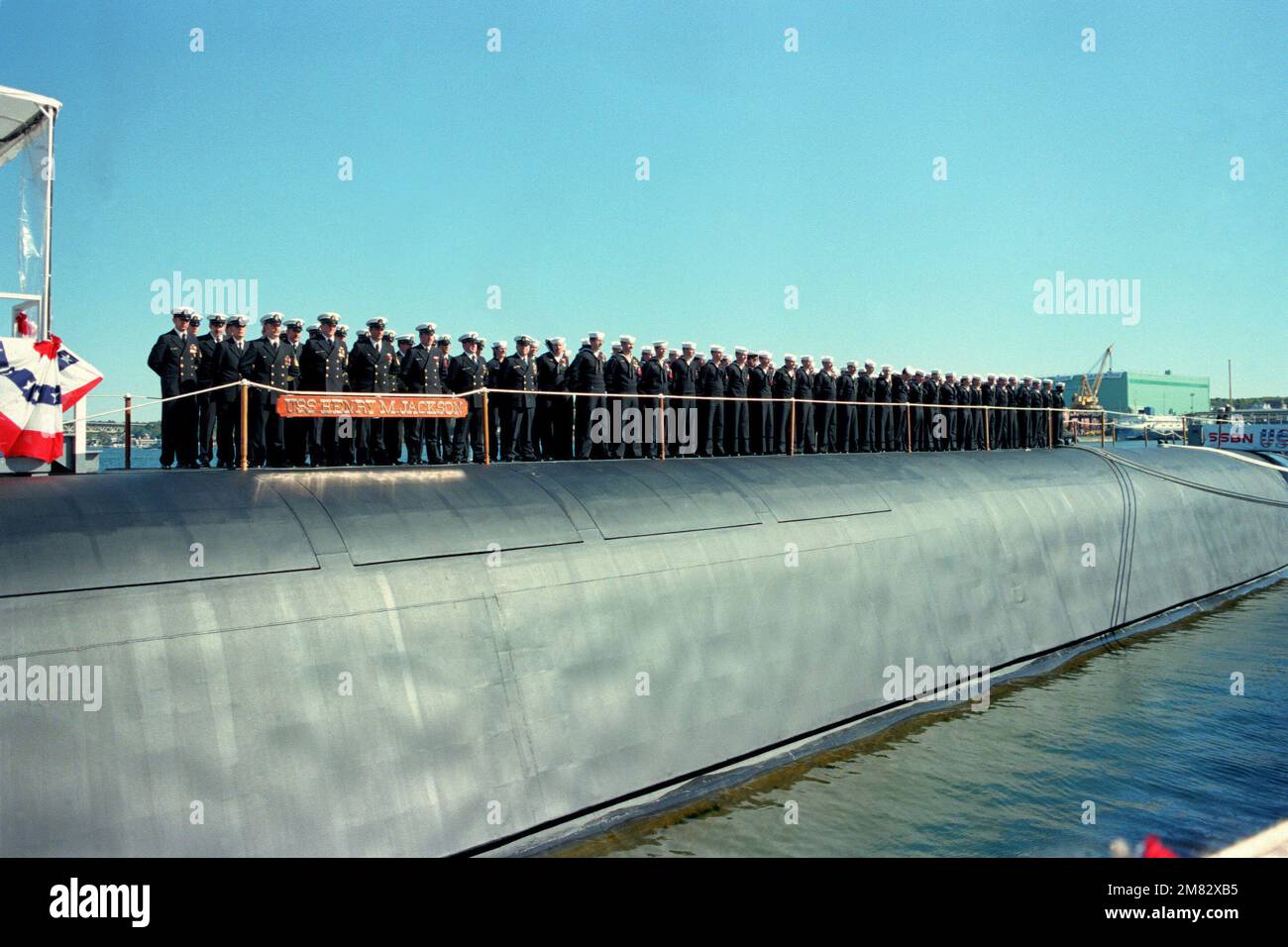 Crewmen stand in formation on the deck of the USS HENRY M. JACKSON ...