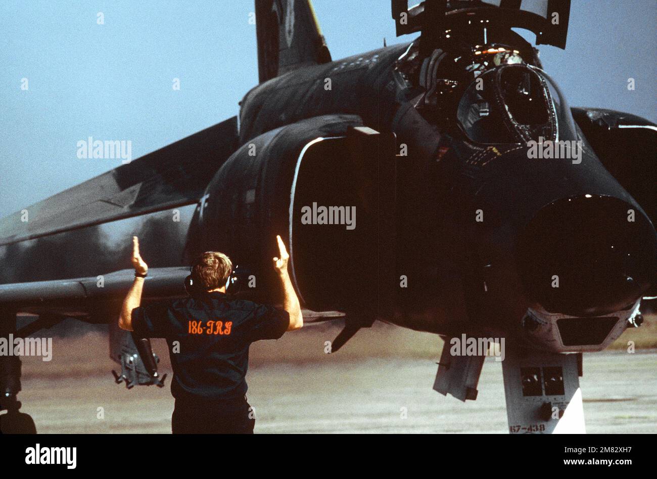 A ground crewman from the 186th Tactical Reconnaissance Group signals ...