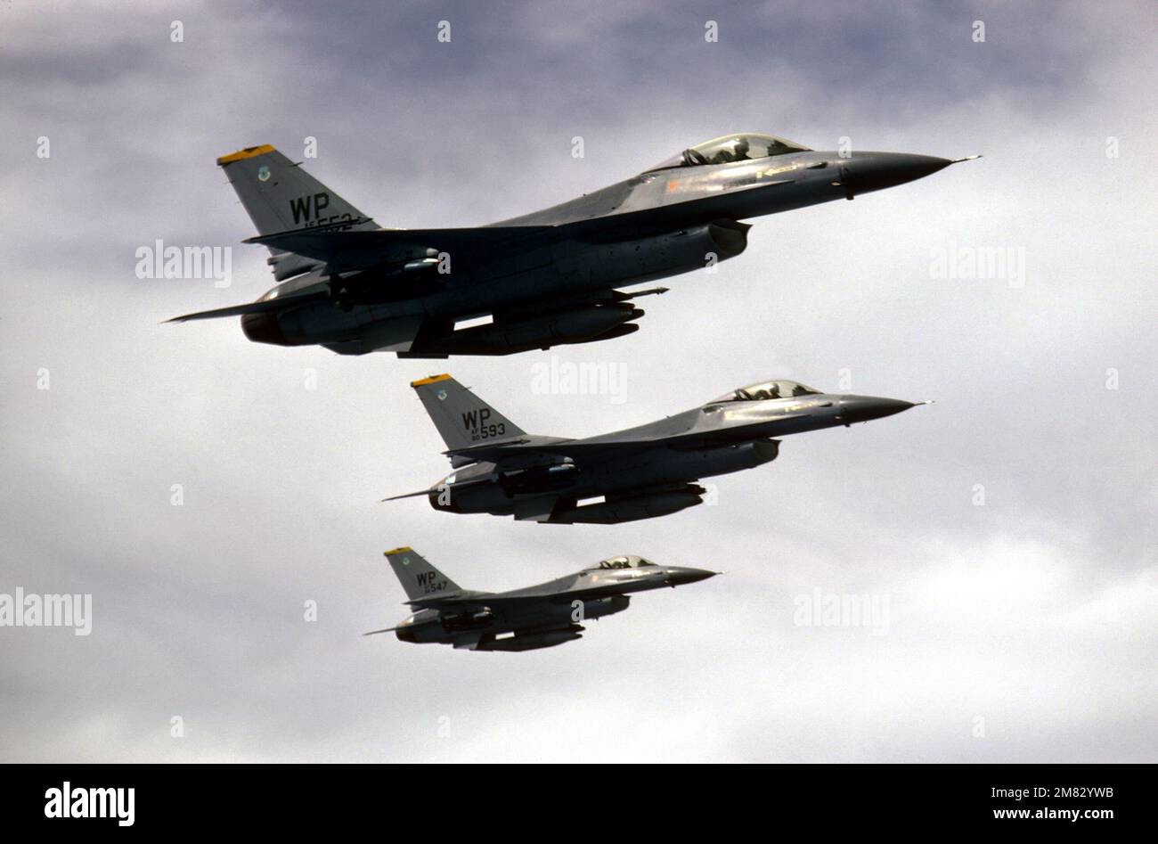 An air-to-air right front view of three F-16 Fighting Falcon aircraft ...