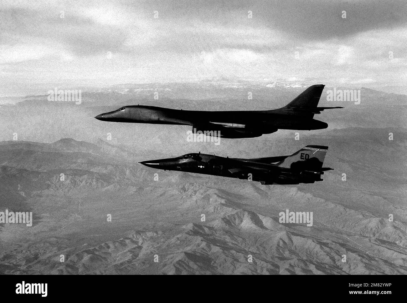 Air-to-air left side view of a B-1B aircraft (above) and an F-111 ...
