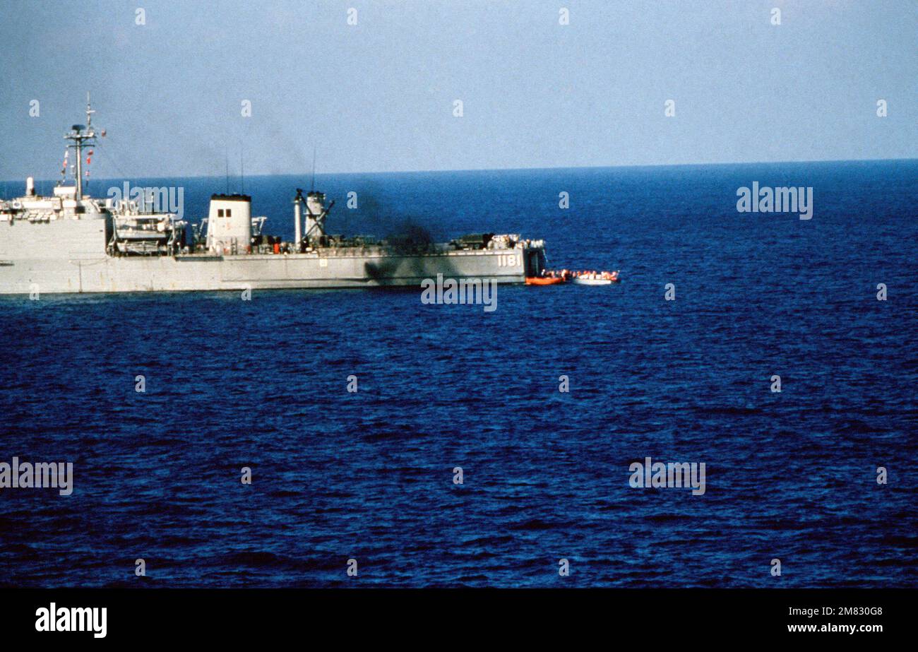 A rescue team exits the docking well of the tank landing ship USS ...