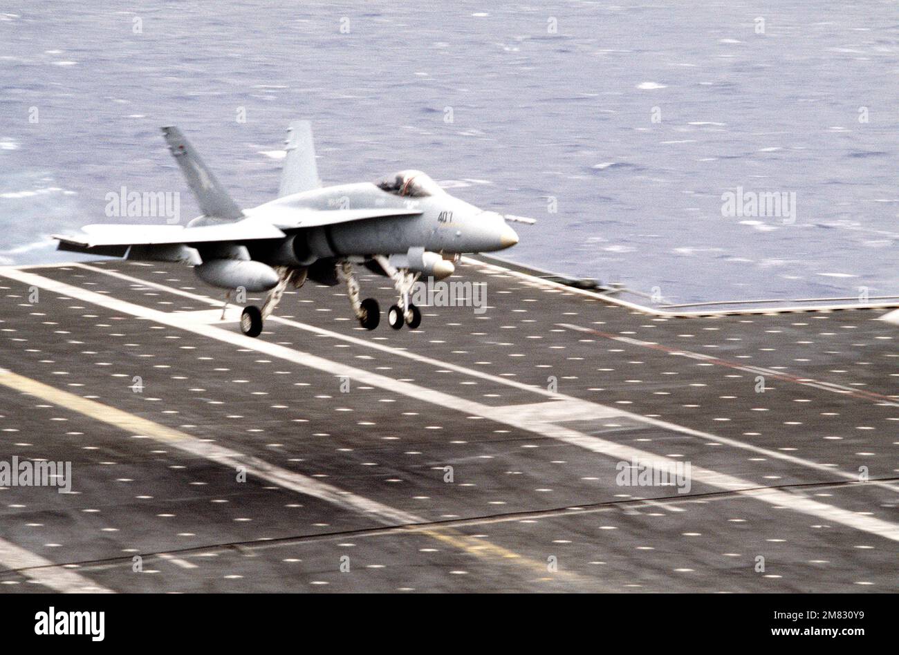 An F/A-18 Hornet aircraft from Strike Fighter Squadron 25 lands aboard ...