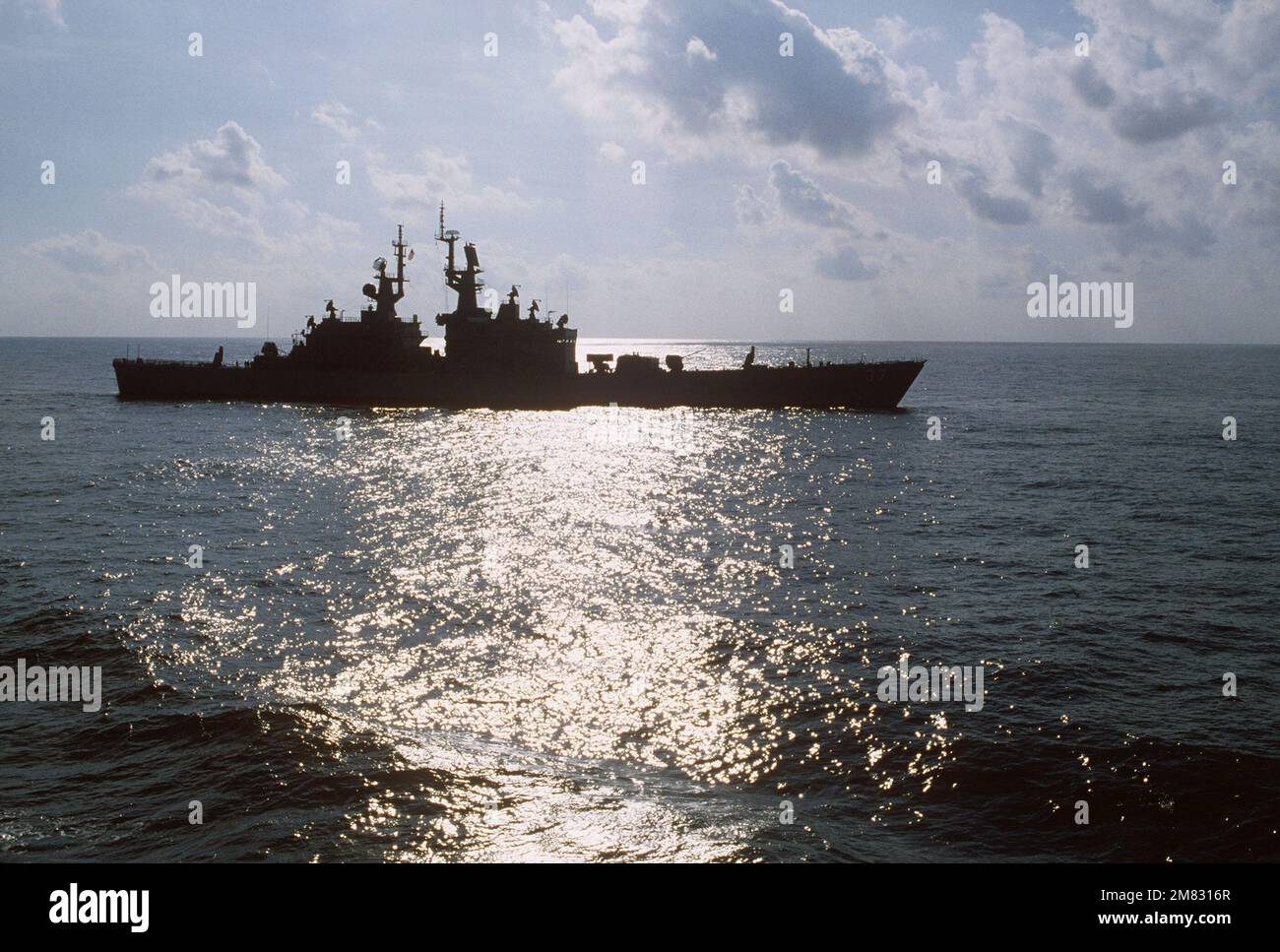 A silhouetted starboard view of the nuclear-powered guided cruiser USS ...