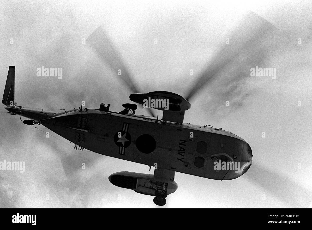 A bottom view of an SH-3 Sea King helicopter hovering over the ...