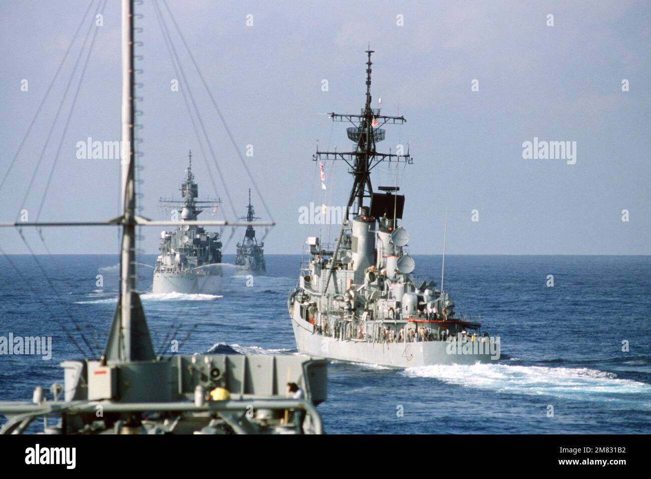 The guided missile destroyer USS BARNEY (DDG 6) follows two ...
