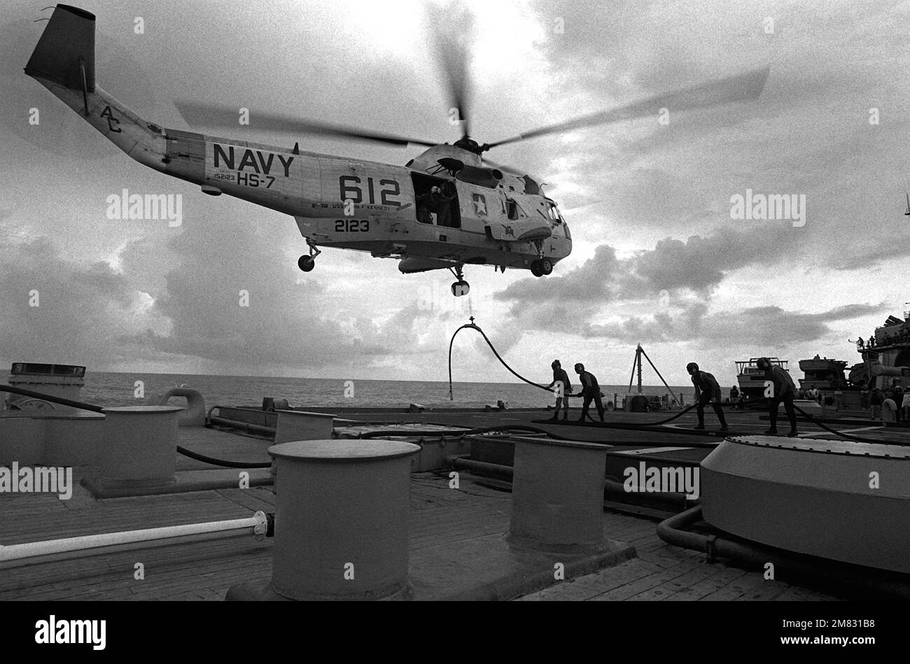 Crew members assist in refueling a Helicopter Anti-submarine Warfare ...
