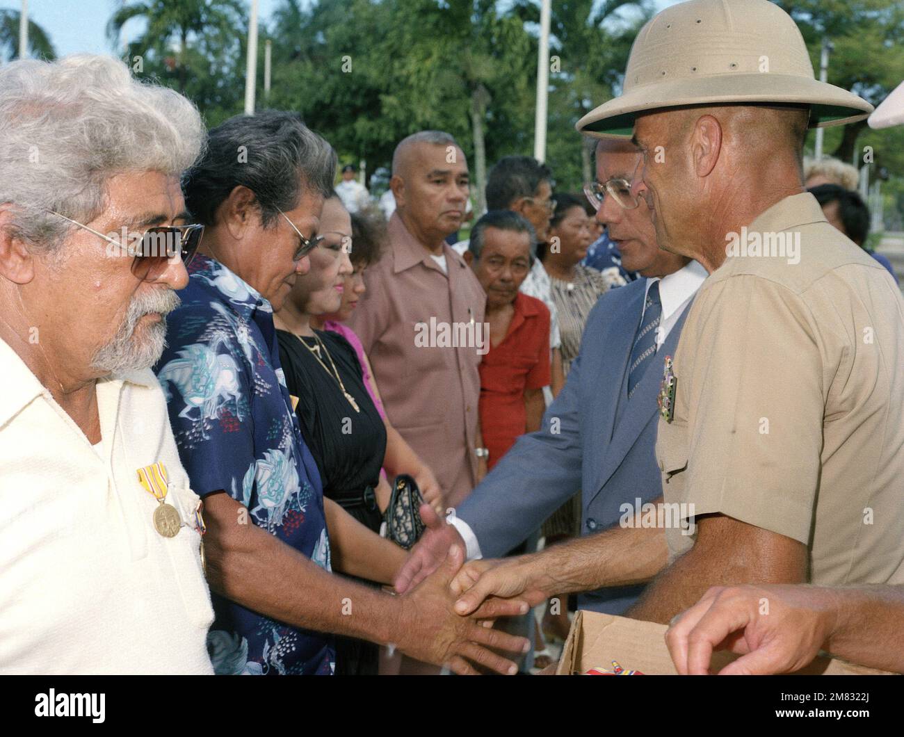 Governor Ricardo J. Bordallo of Guam shakes hands with one of the 34 ...
