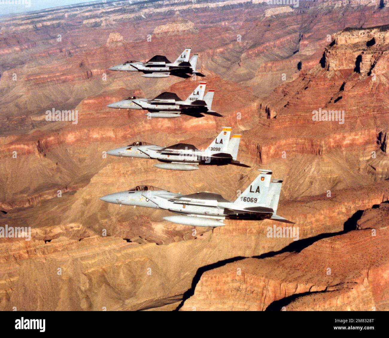 An air-to-air left side view of four F-15 Eagle aircraft in echelon ...