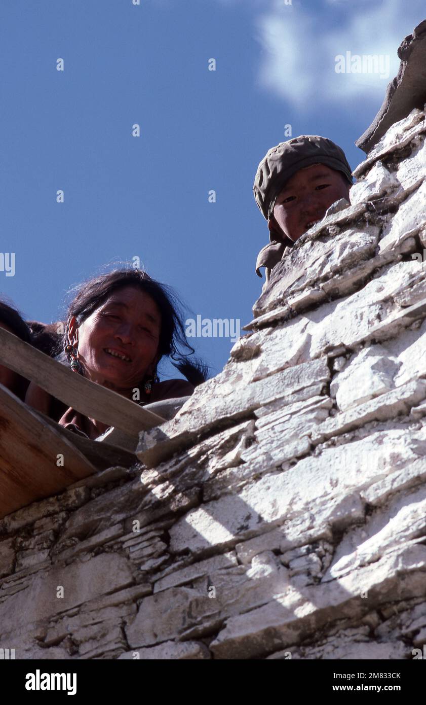 WOMEN AND YOUNG CHILD PEERING OVER A WALL, CHINA Stock Photo - Alamy