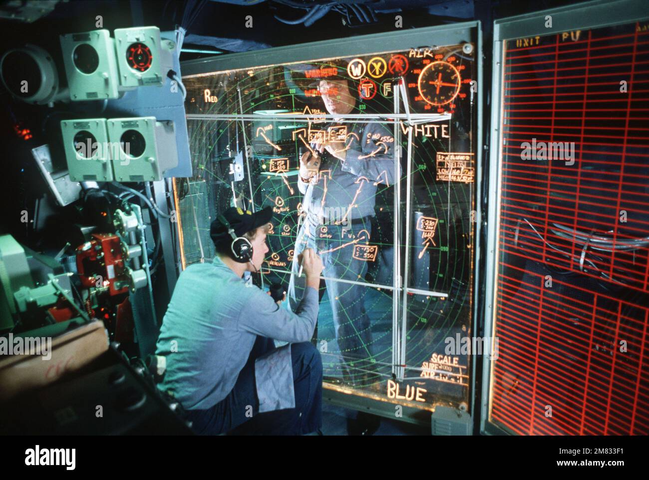 Crew members work in the combat engagement center aboard the battleship ...