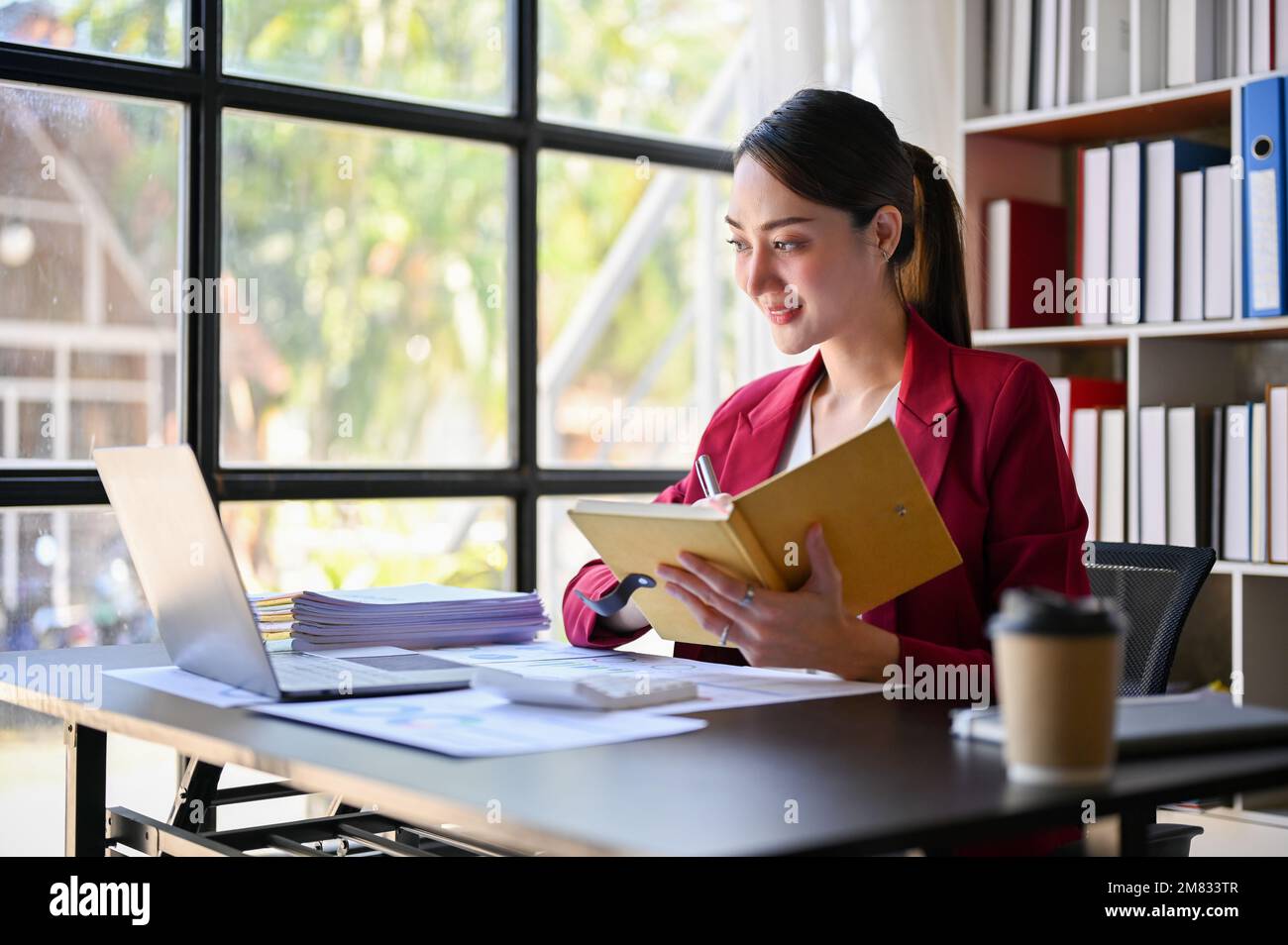 Attractive and professional millennial Asian businesswoman using laptop ...