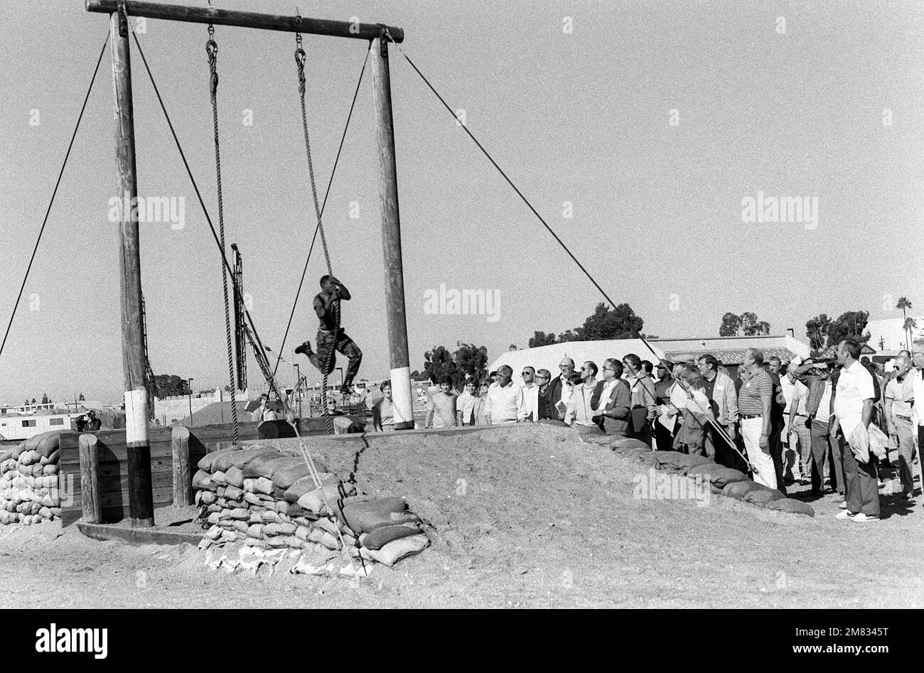 A Marine instructor demonstrates the rope swing obstacle for a group of ...