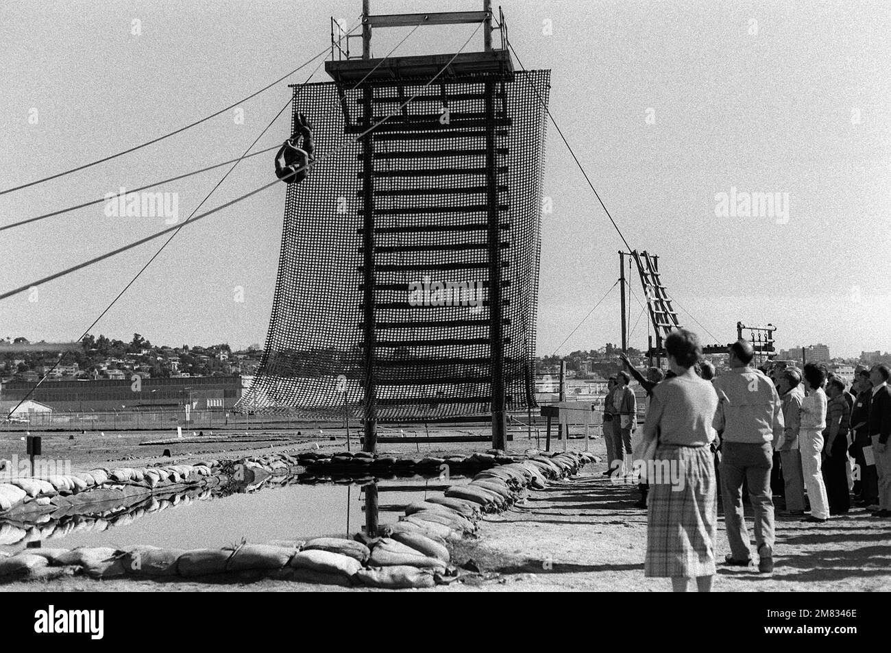 A recruit descends the slide for life obstacle as a group of civilian ...