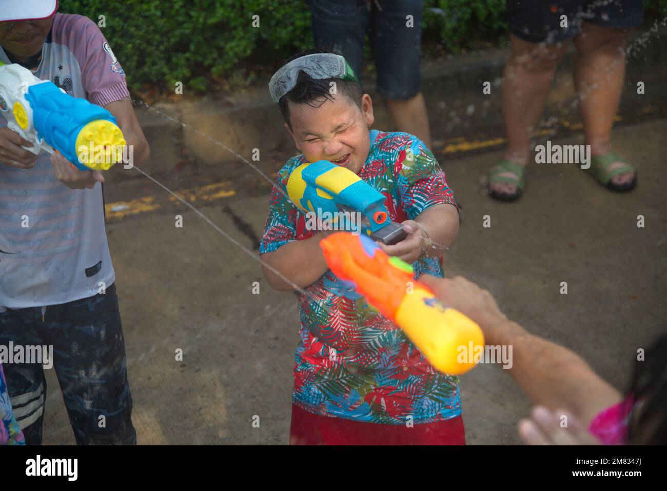 An unidentified little boy playing water spray with plastic gun. Join ...