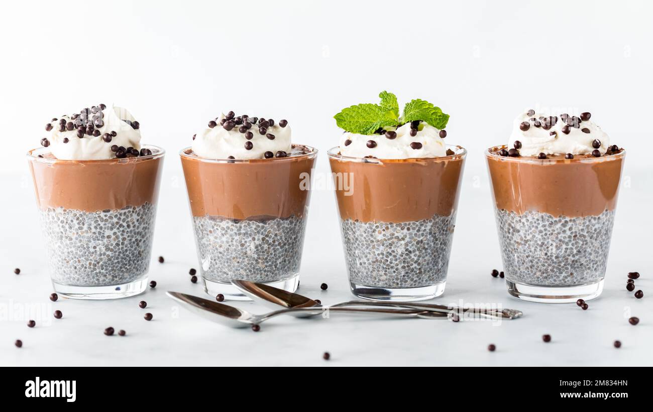 A row of chocolate chia pudding desserts with spoons in front, ready ...