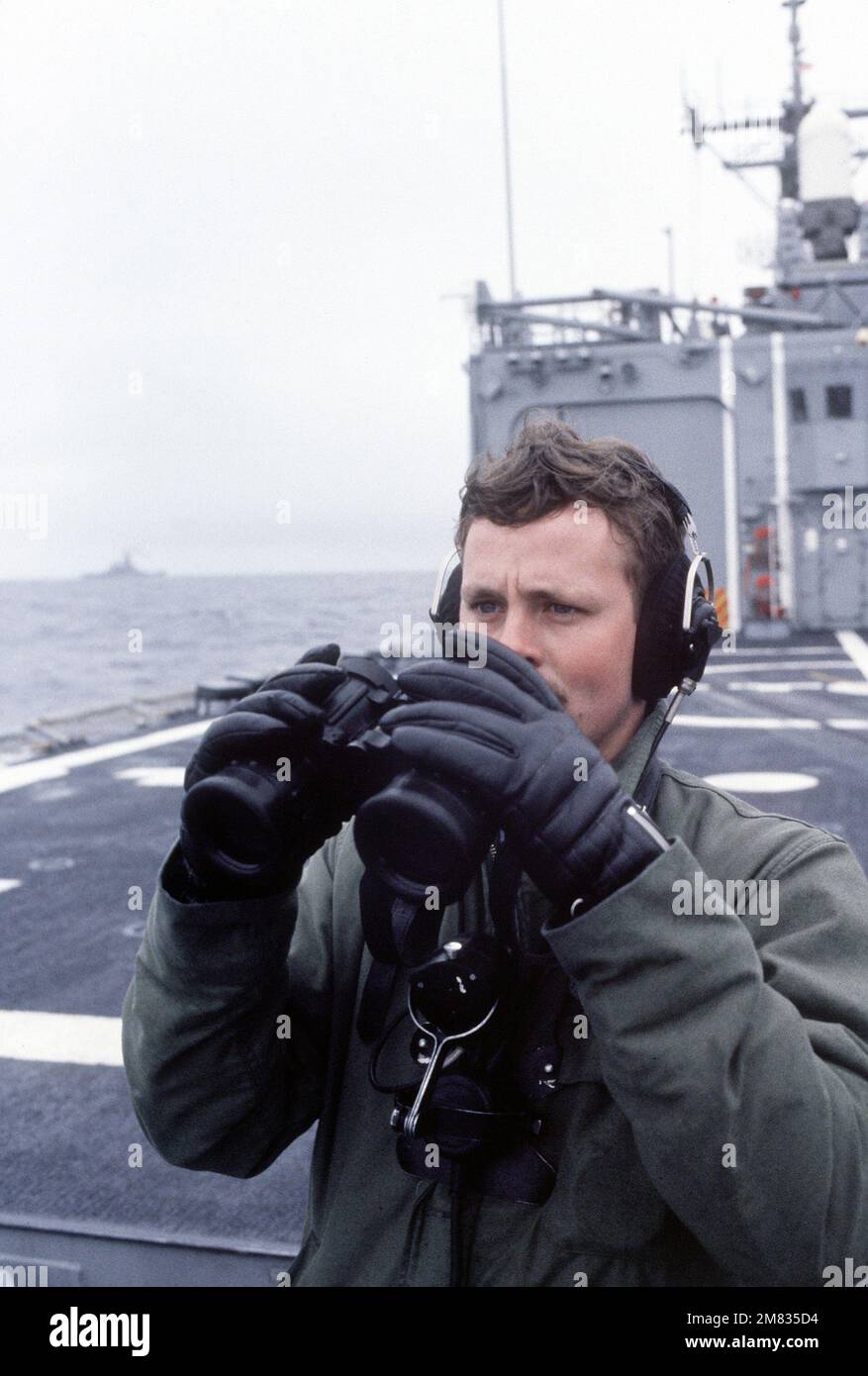 A sailor on the fantail of the guided missile frigate USS HALYBURTON ...