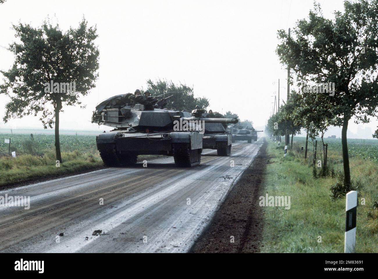 Three M1 Arams main battle tanks maneuver into firing positions during ...