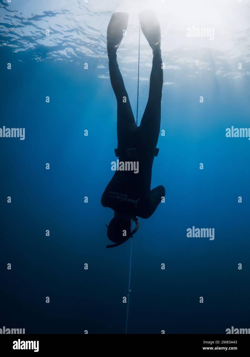 October 03, 2022. Amed, Indonesia. Men in wetsuit with fins training ...