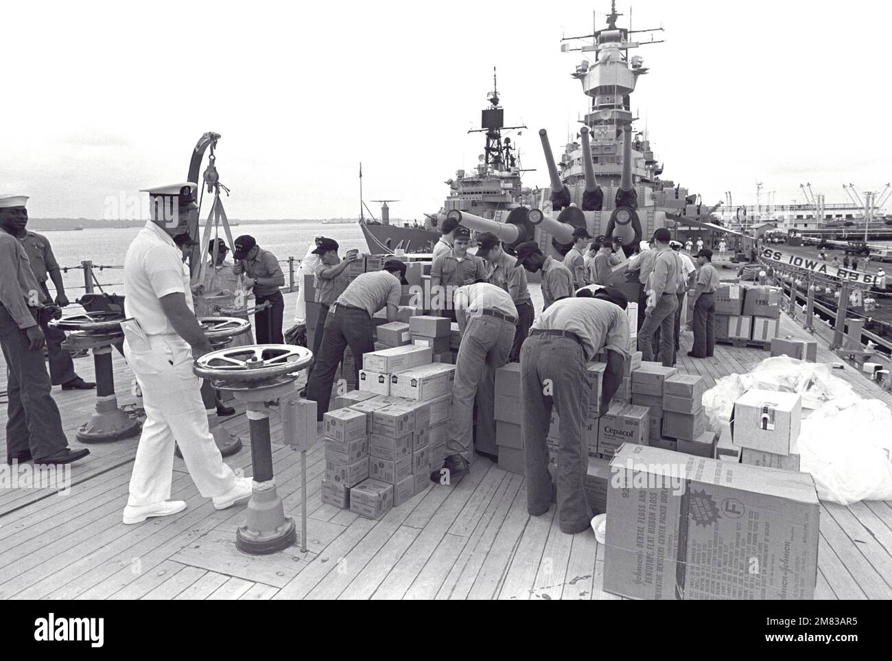 Crew members load Project Handclasp materials aboard the battleship USS ...